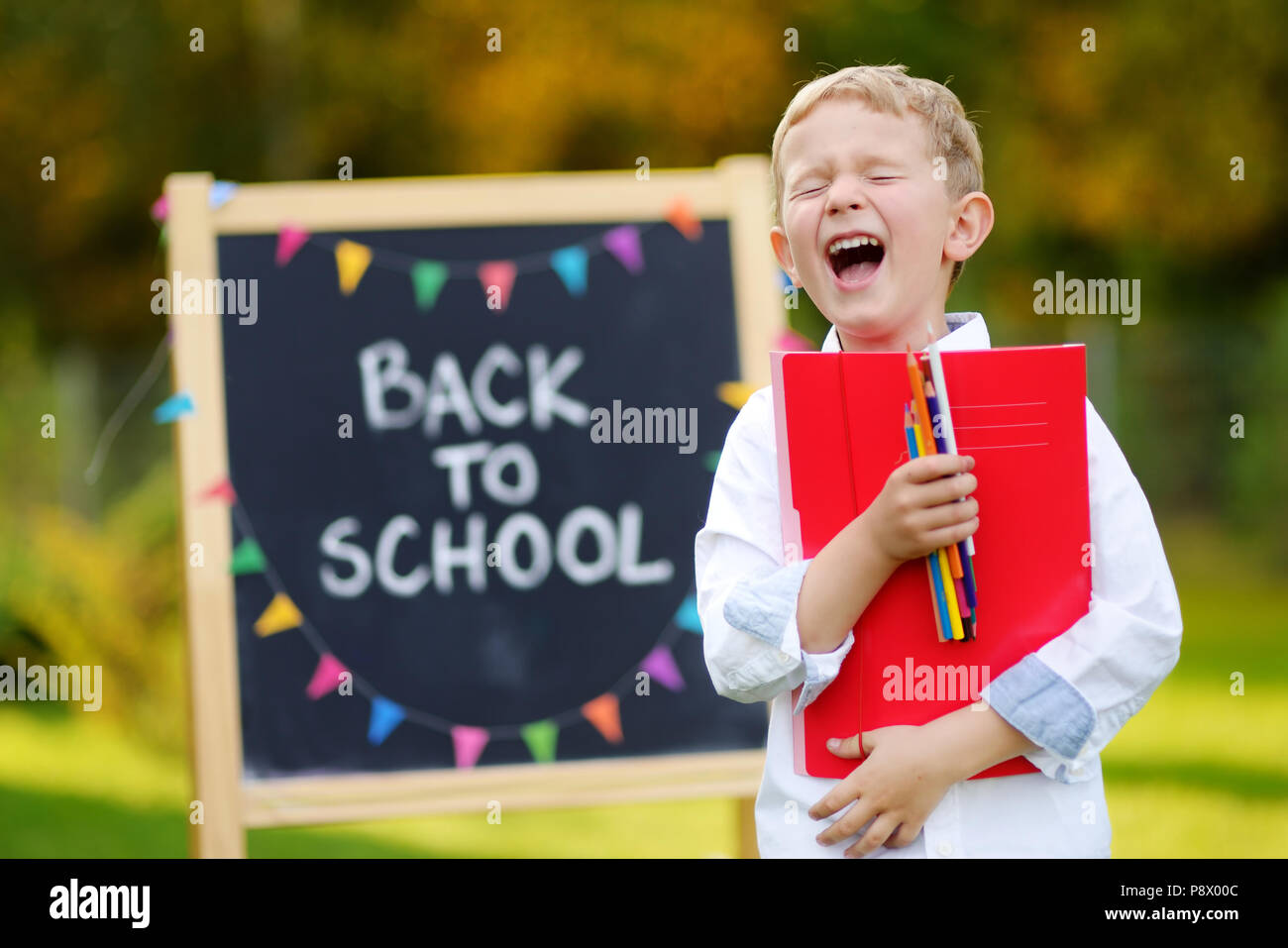 Adorable little boy feeling very exited about going back to school ...
