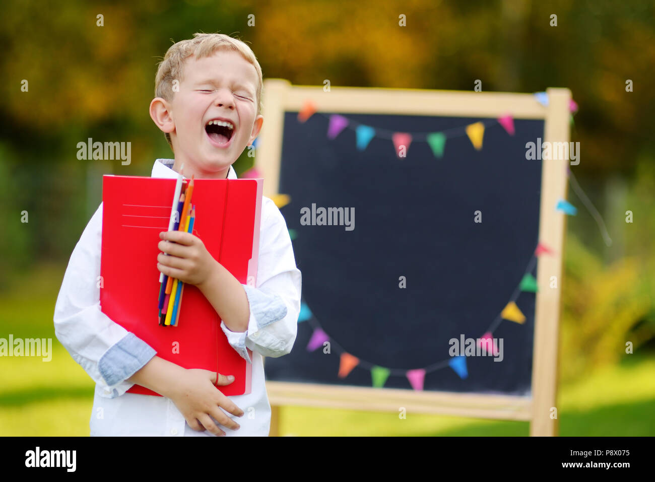Adorable little boy feeling very exited about going back to school ...