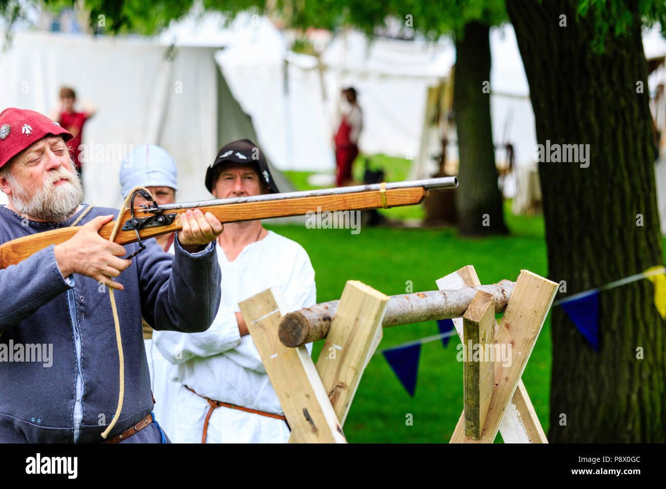 Man in medieval costume, about to fire harquebus, arquebus, early ...