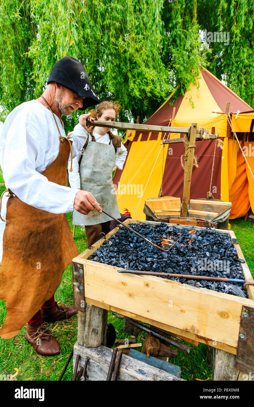 Living history, outdoor re-enactment event. Medieval man, blacksmith ...