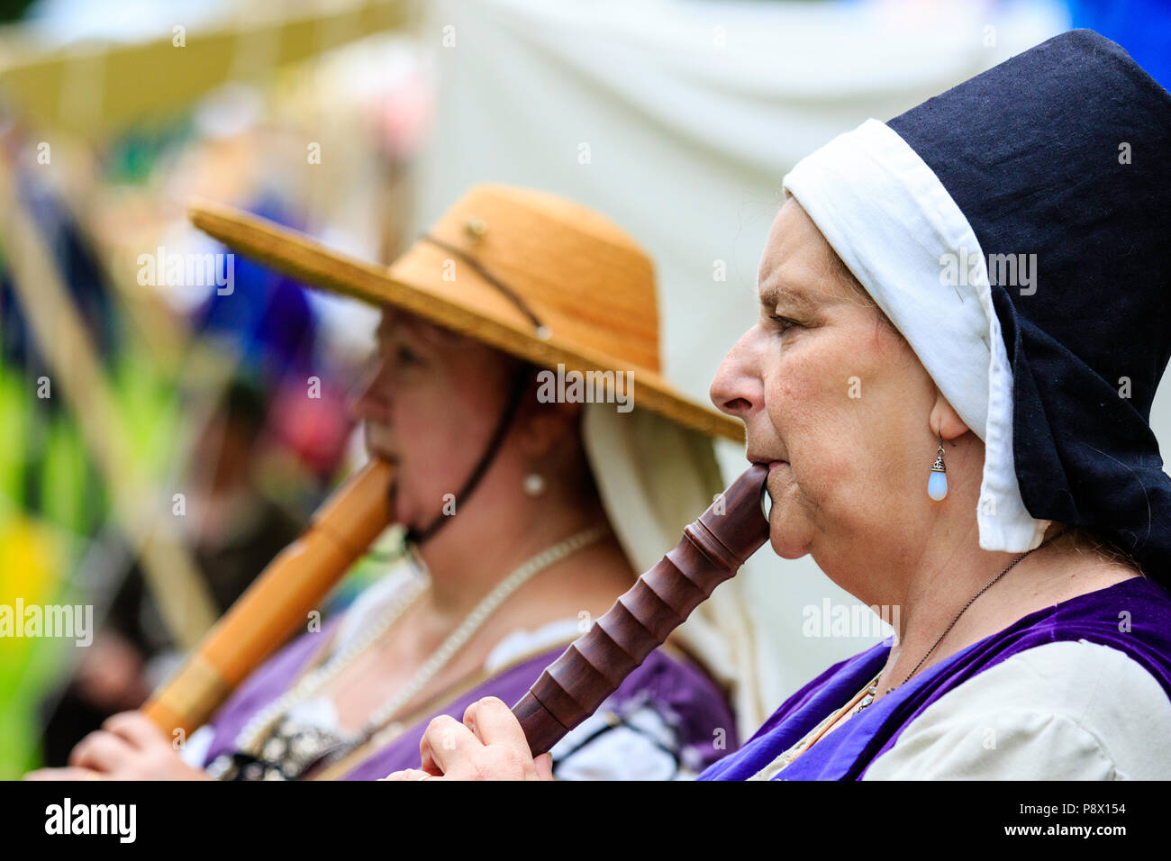 Two women wearing outfits of medieval traveling minstrel, entertainer ...