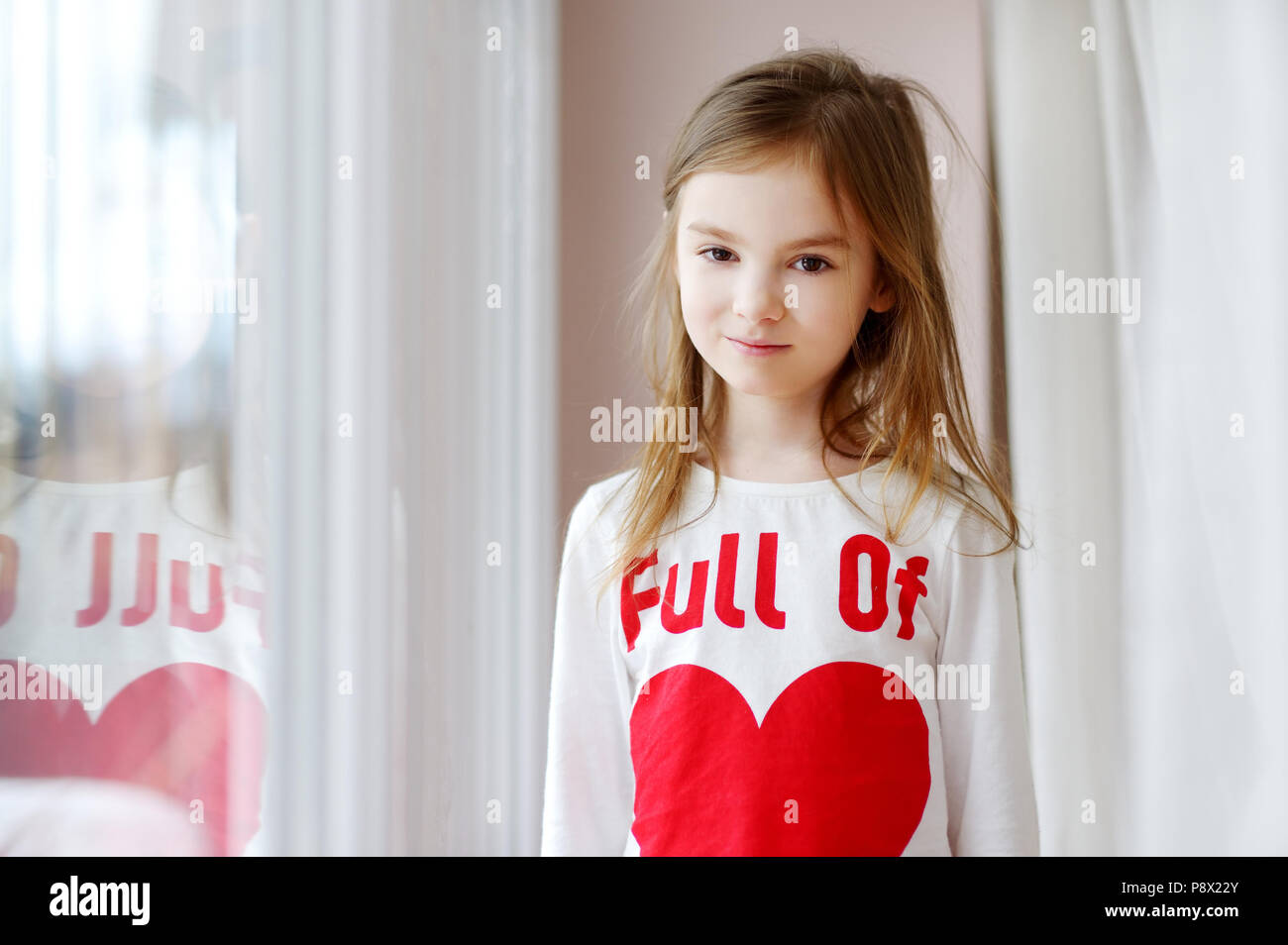 Adorable smiling little girl wearing funny tshirt by the window Stock ...