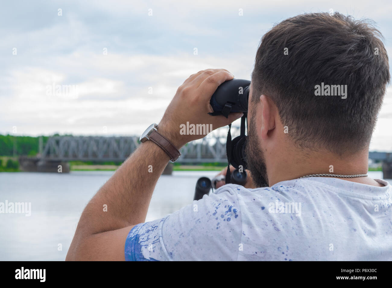 Captain looks through a binoculars - marine concept. Young man with ...