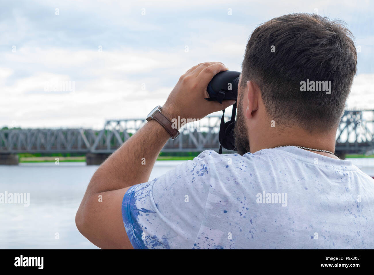 Captain looks through a binoculars - marine concept. Young man with ...