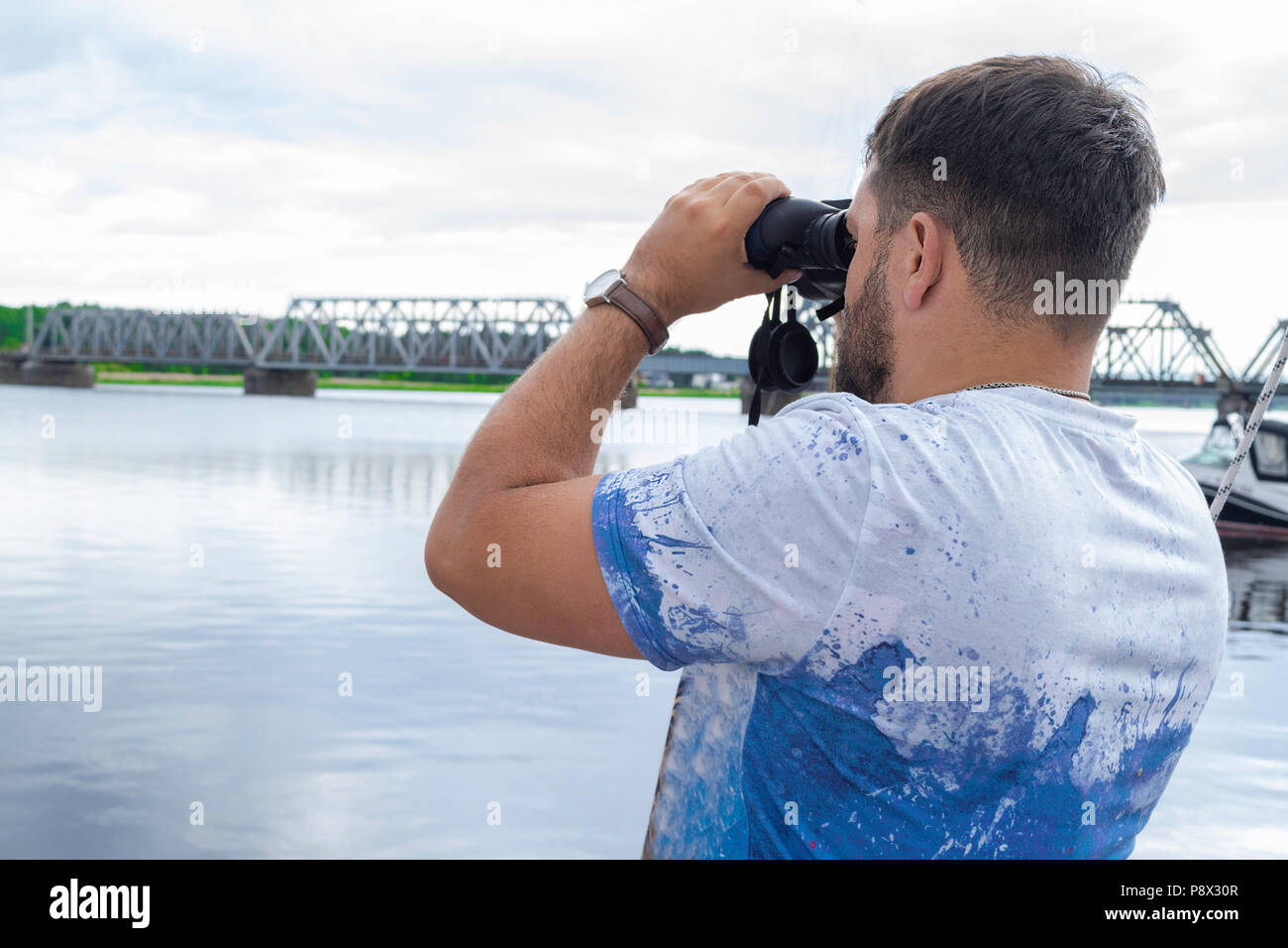 Captain looks through a binoculars - marine concept. Young man with ...