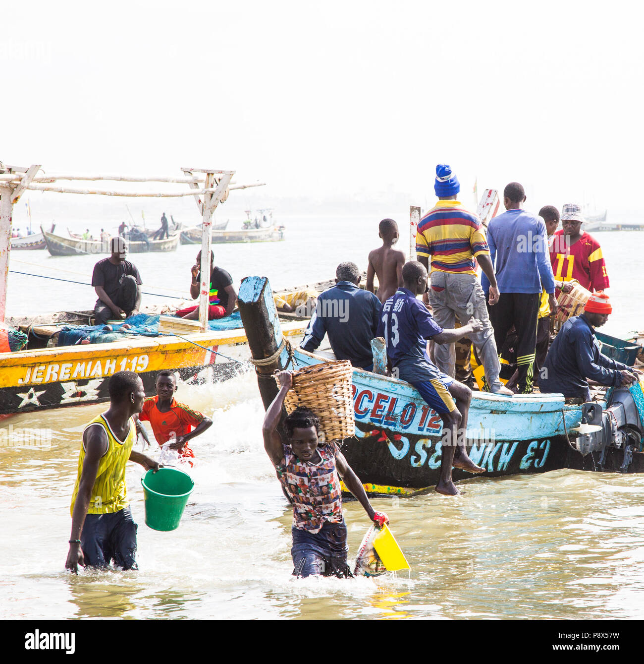 Fishermen carrying freshly caught fish from the boats, Accra, Ghana ...