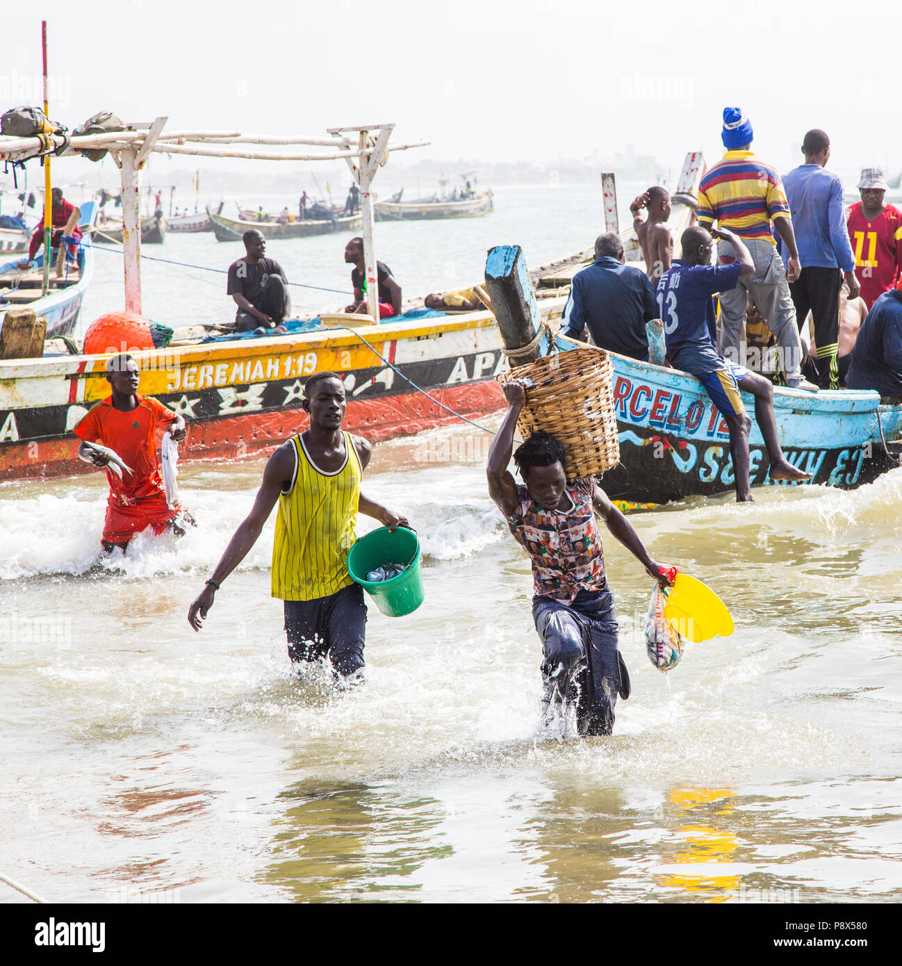 Fishermen carrying freshly caught fish from the boats, Accra, Ghana ...