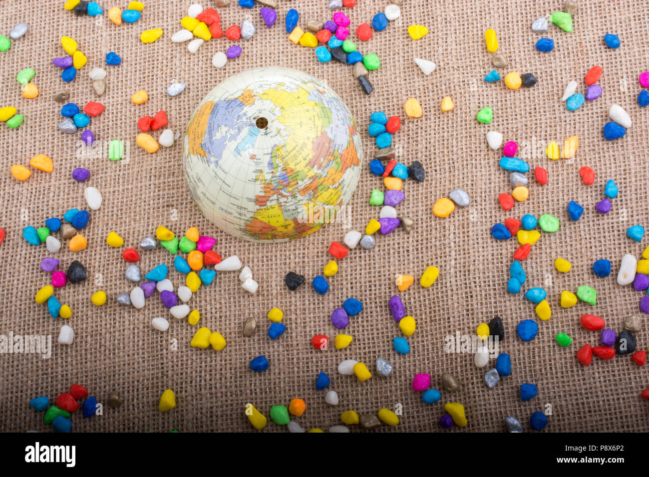Model globe placed amid colorful pebbles Stock Photo - Alamy