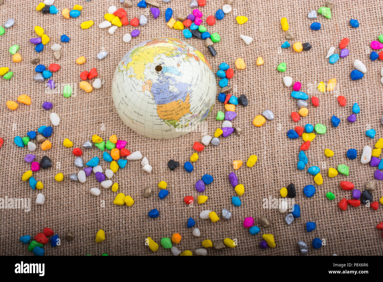 Model globe placed amid colorful pebbles Stock Photo - Alamy