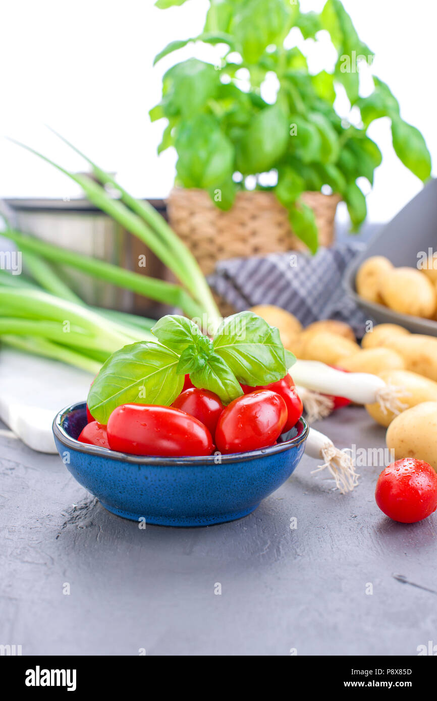 Fresh green onions, young potatoes, cherry tomatoes and green basil ...