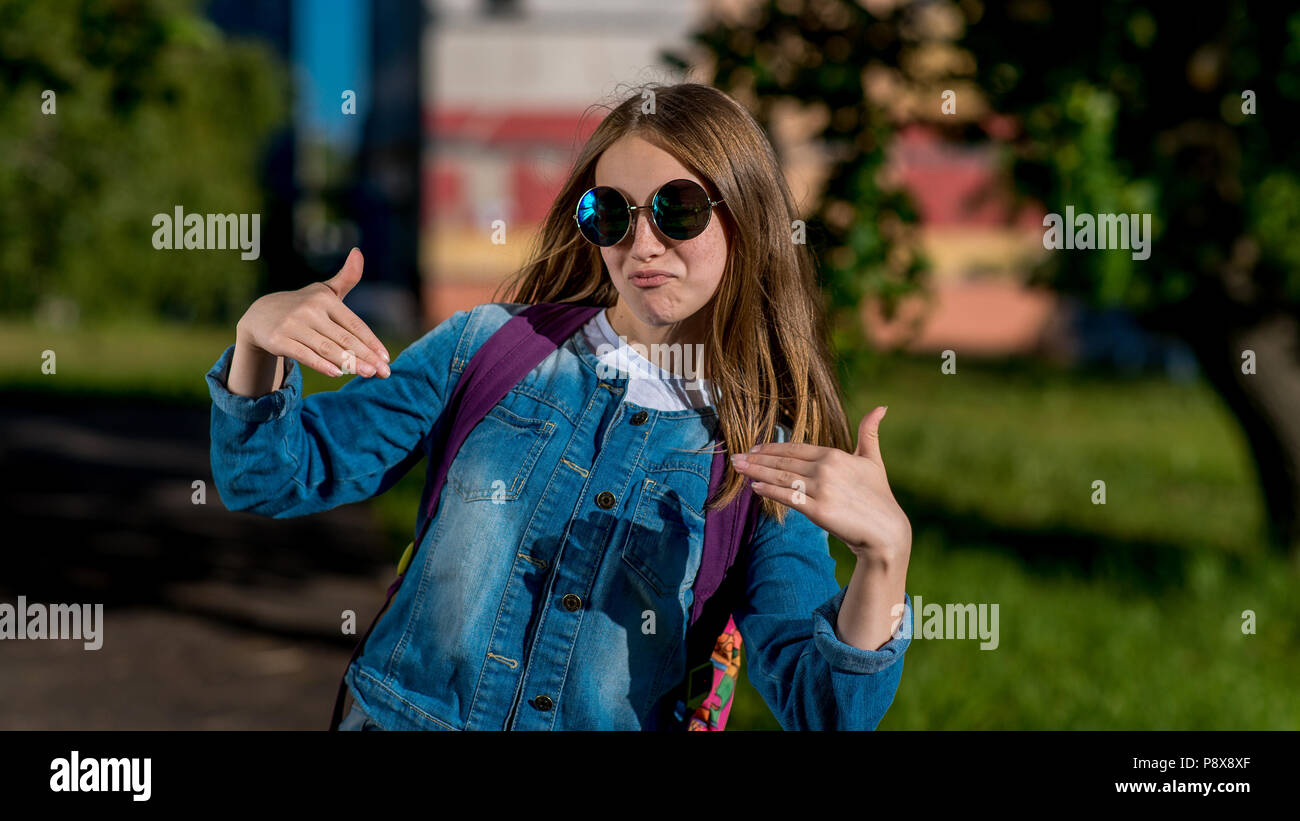 Beautiful little girl teenager in jeans clothes in summer in the city ...