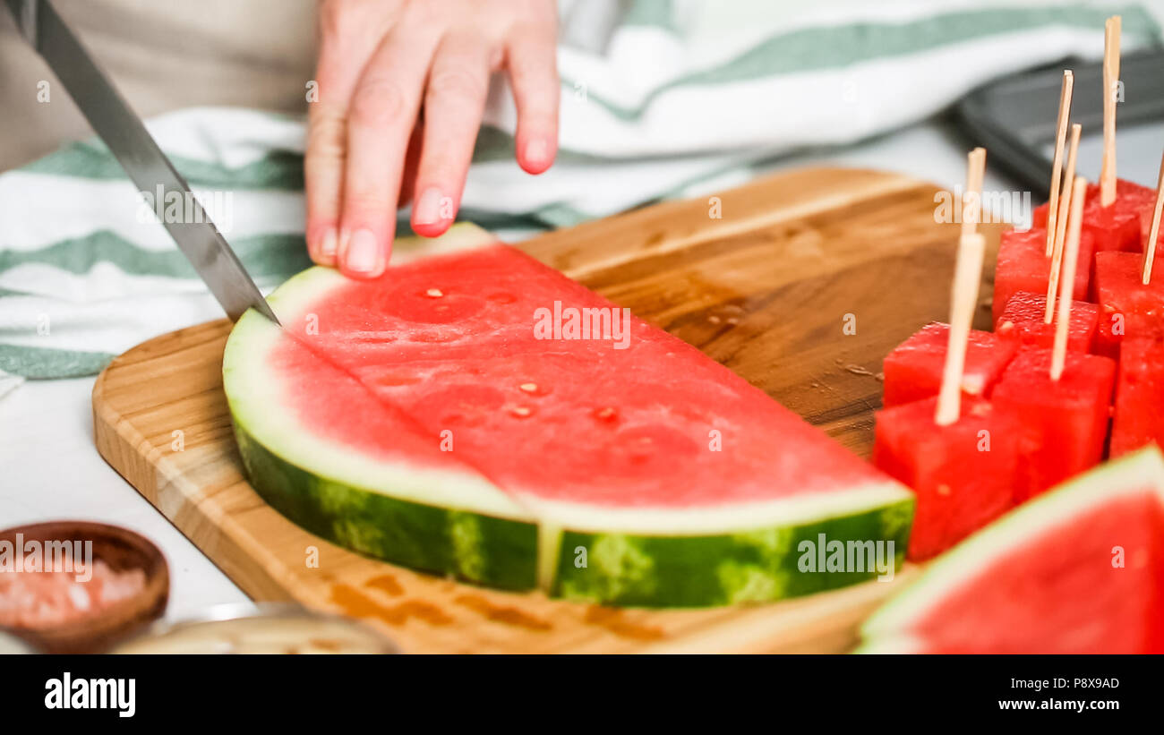 Slicing watermelon into cubes for preparing chocolate covered ...