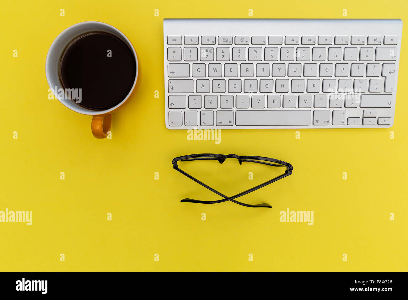 Computer keyboard on bright yellow background minimal workspace concept ...