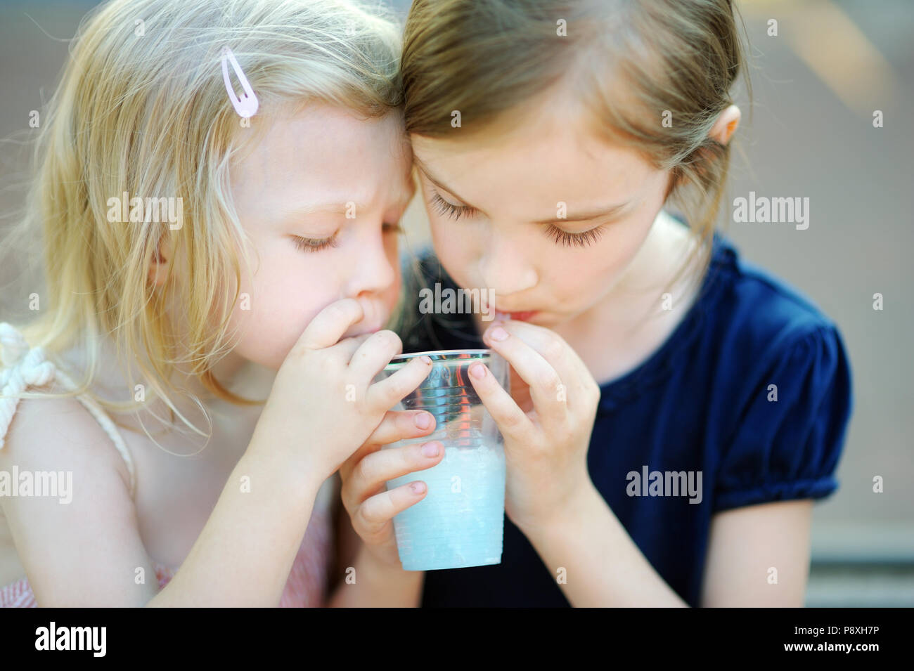Two cute little sisters drinking cold lemonade on hot summer day Stock ...