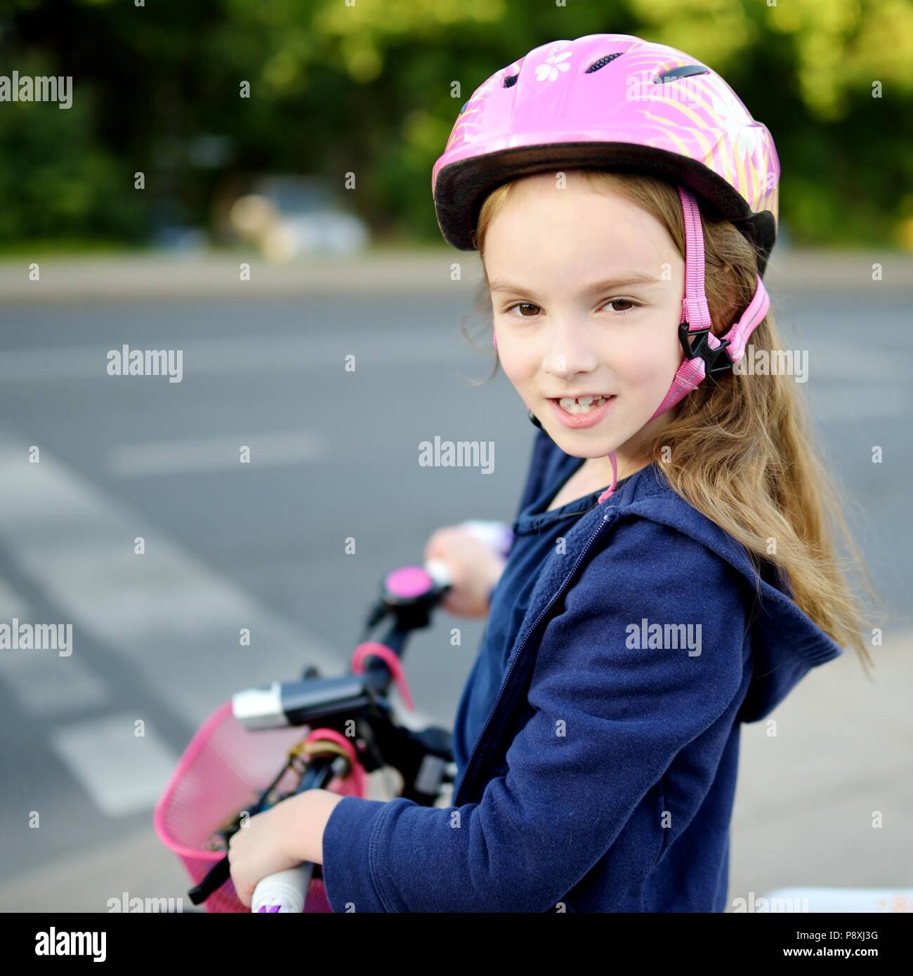 Girl wearing helmet while riding bike hi-res stock photography and ...