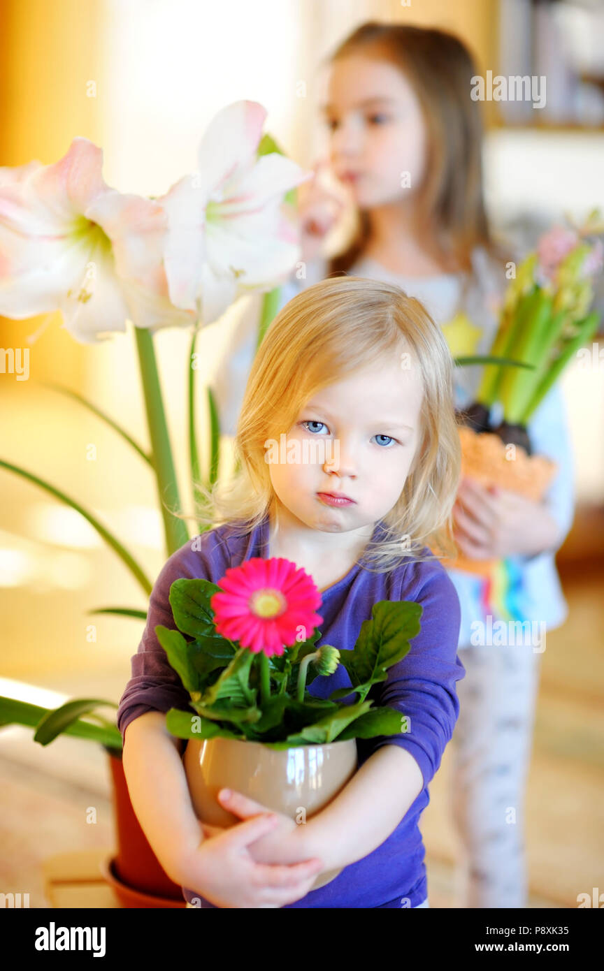 Adorable little girl taking care of plants and flowers at home Stock ...
