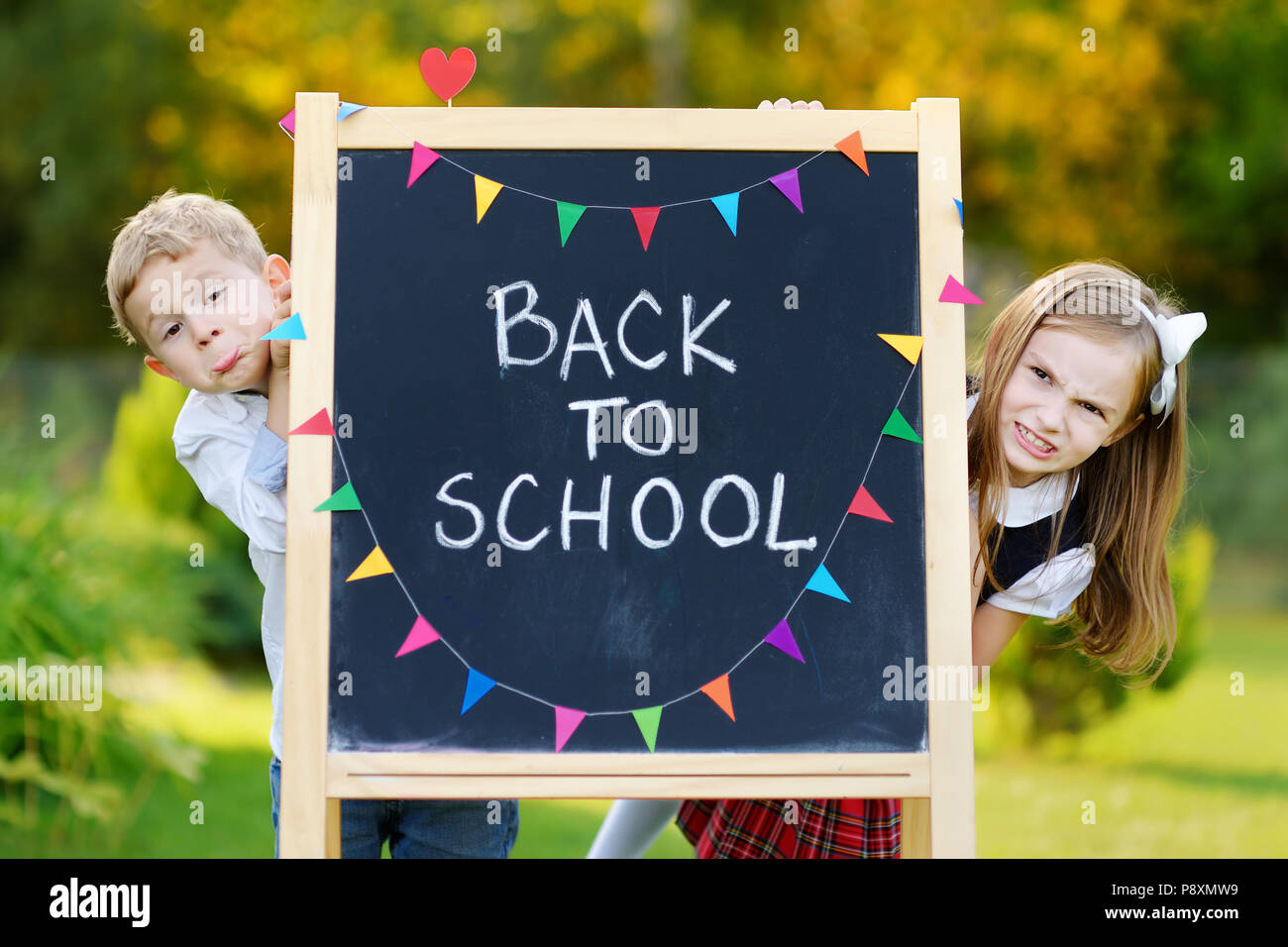 Two adorable little schoolkids feeling very exited about going back to ...
