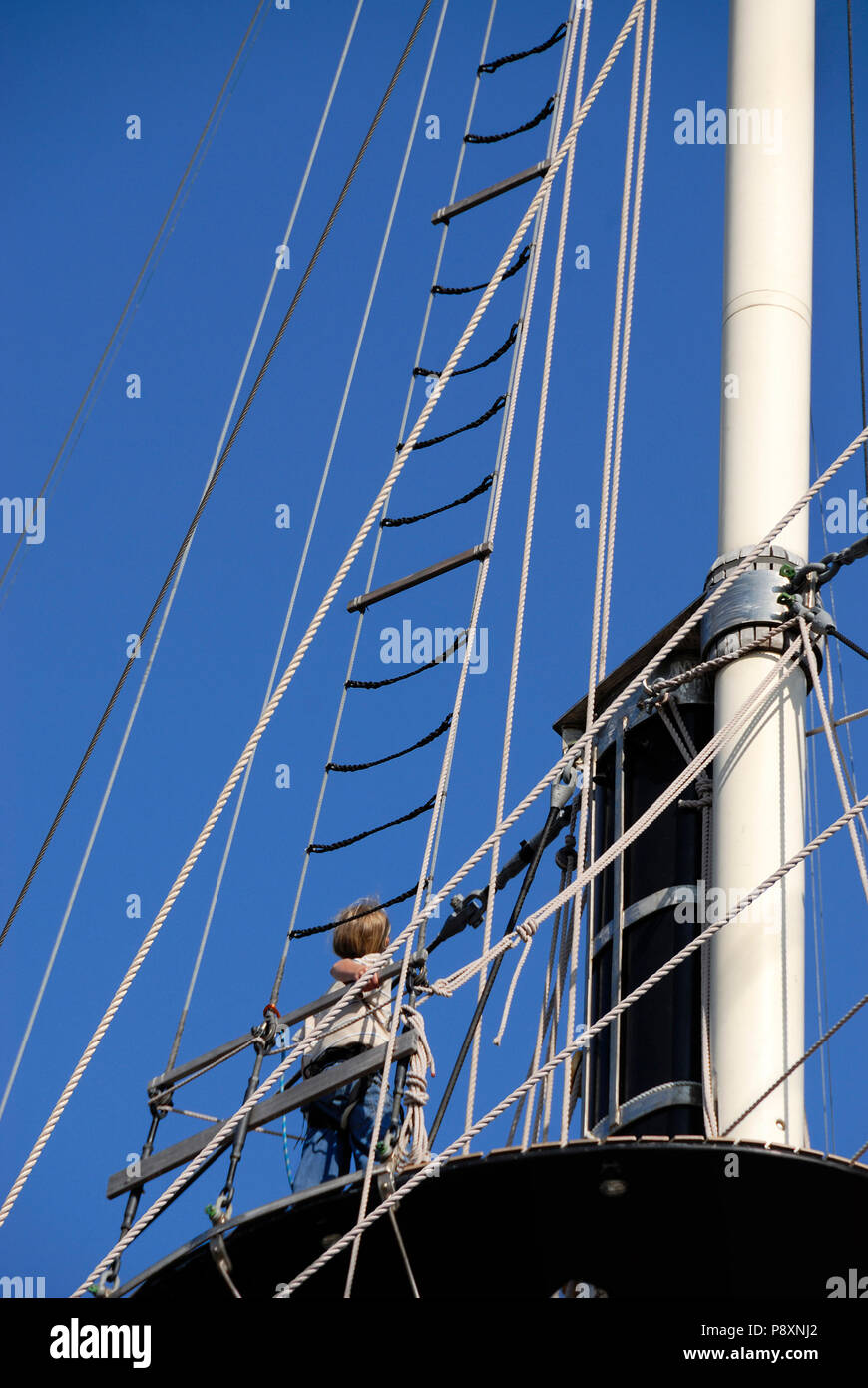 Youth contemplates going higher on a tall ship mast Stock Photo - Alamy