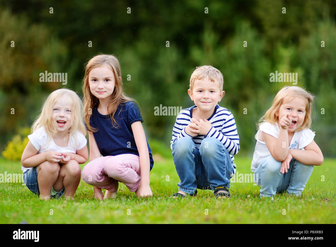 Four adorable little kids outdoors at warm summer day Stock Photo - Alamy