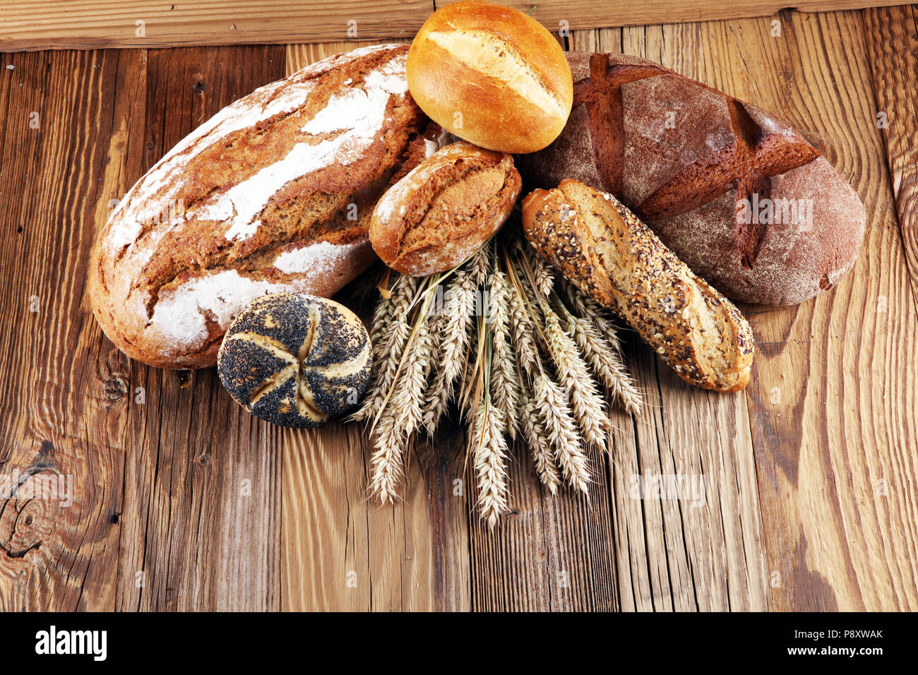 Different kinds of bread and bread rolls on board from above. Kitchen ...