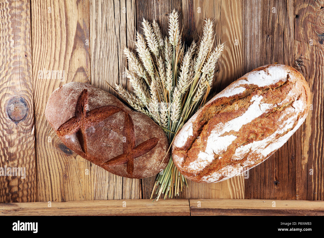 Different kinds of bread and bread rolls on board from above. Kitchen ...