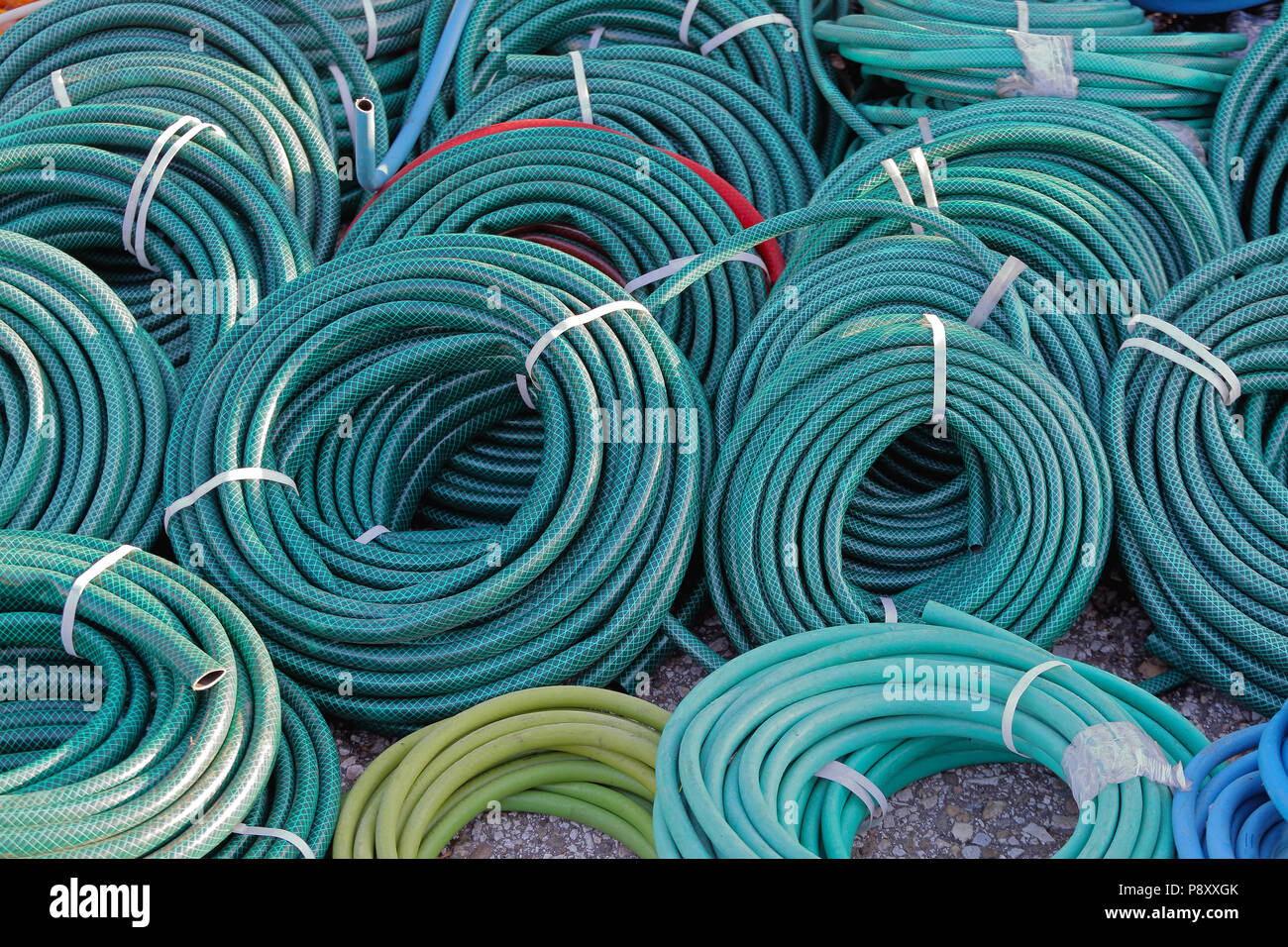 Big bunch of green garden hose coils Stock Photo - Alamy