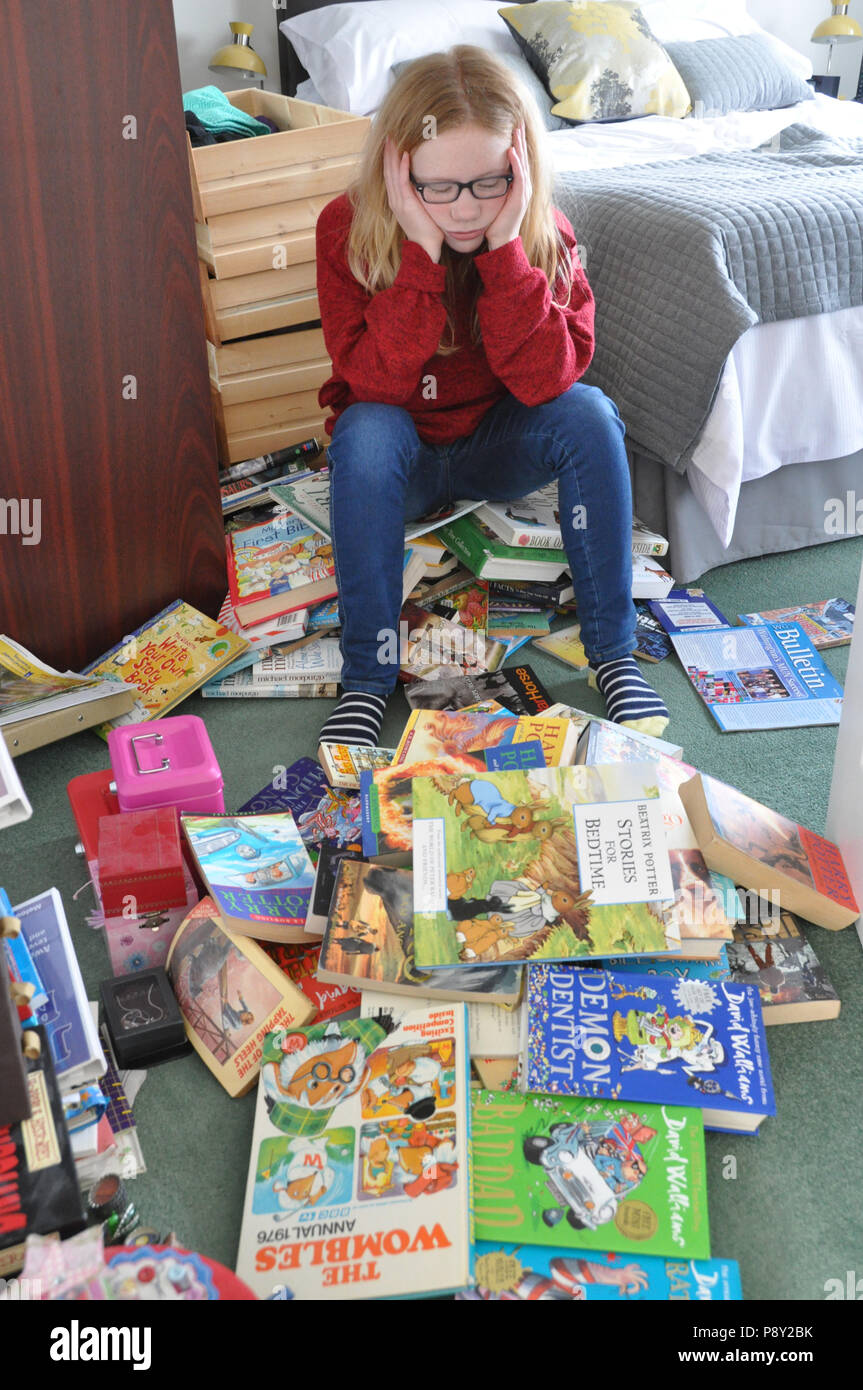 Girl sorting out her books, frustrated Stock Photo - Alamy