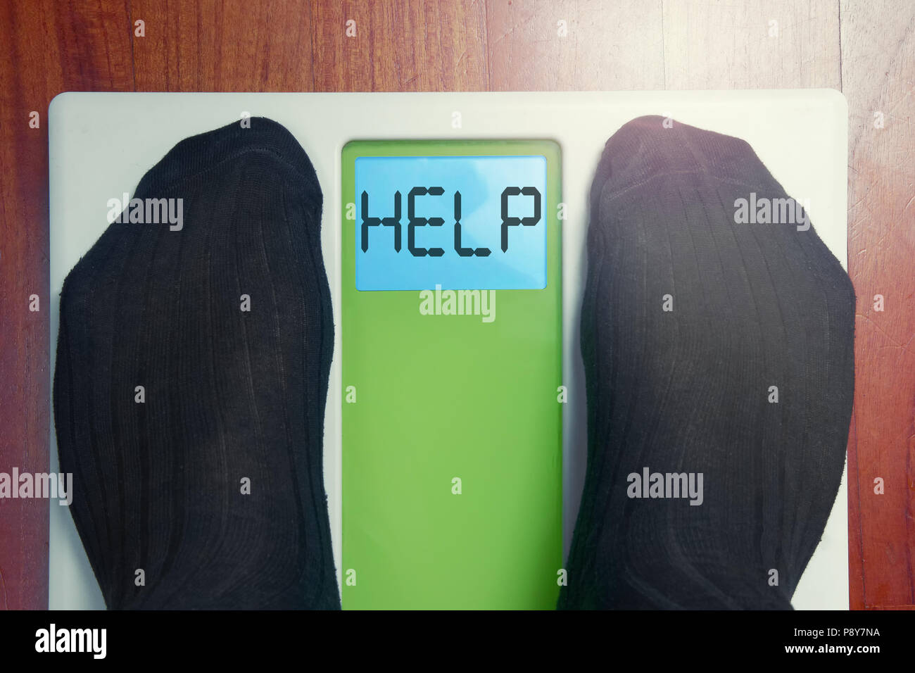 Closeup male feet on scale at morning Help word Stock Photo - Alamy