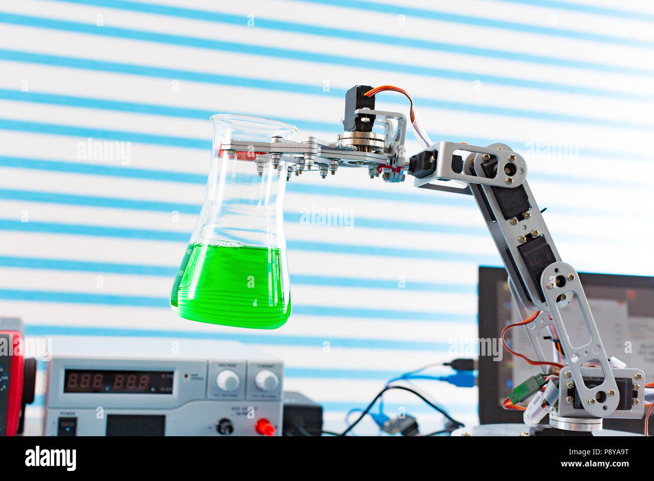 Robotic arm holding flask Stock Photo - Alamy