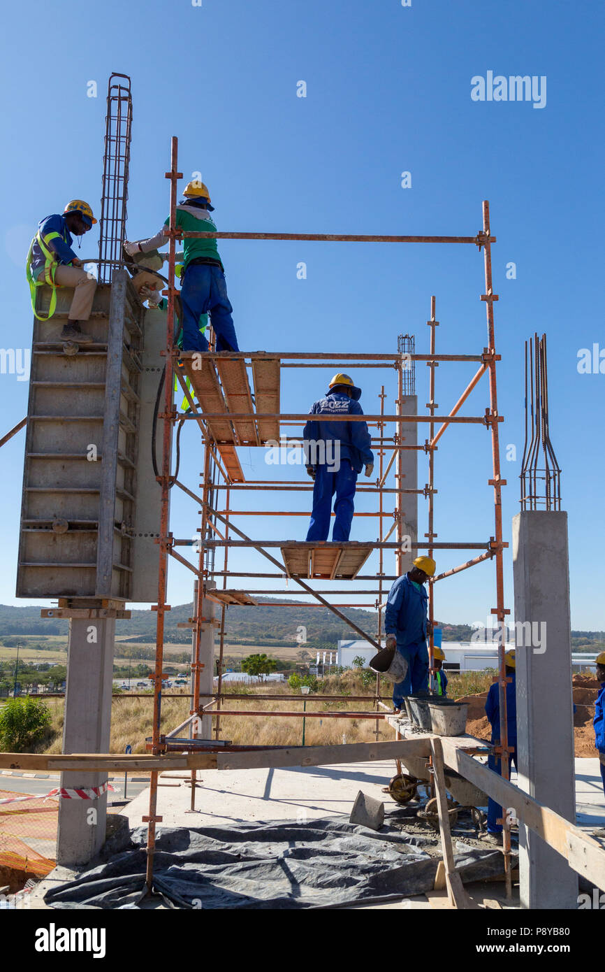 Construction workers building a pillar on an outdoor construction site ...