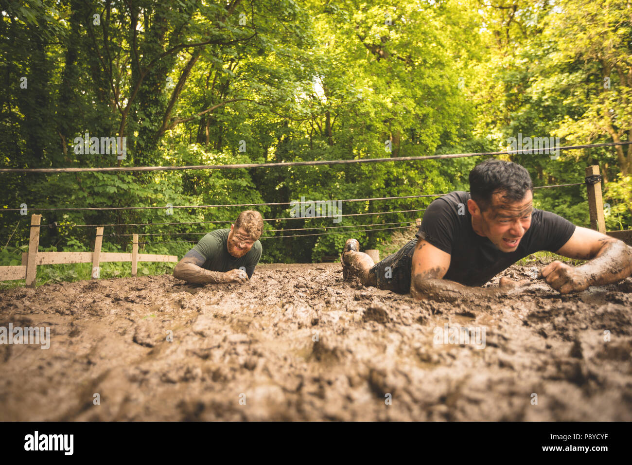 Fit men training under obstacle course Stock Photo - Alamy
