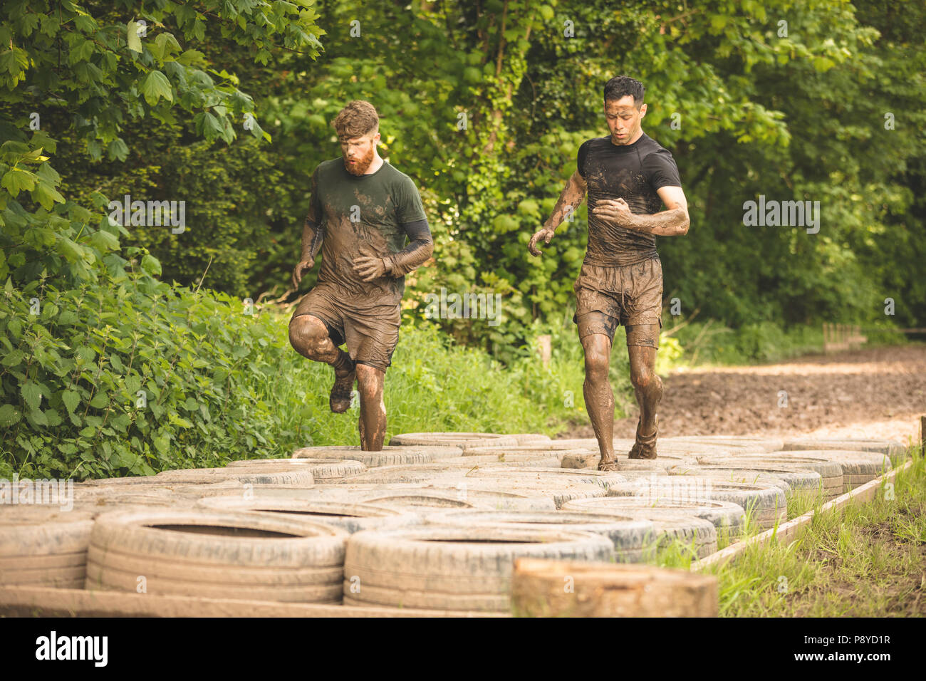Fit mens training over tyres obstacle course Stock Photo - Alamy