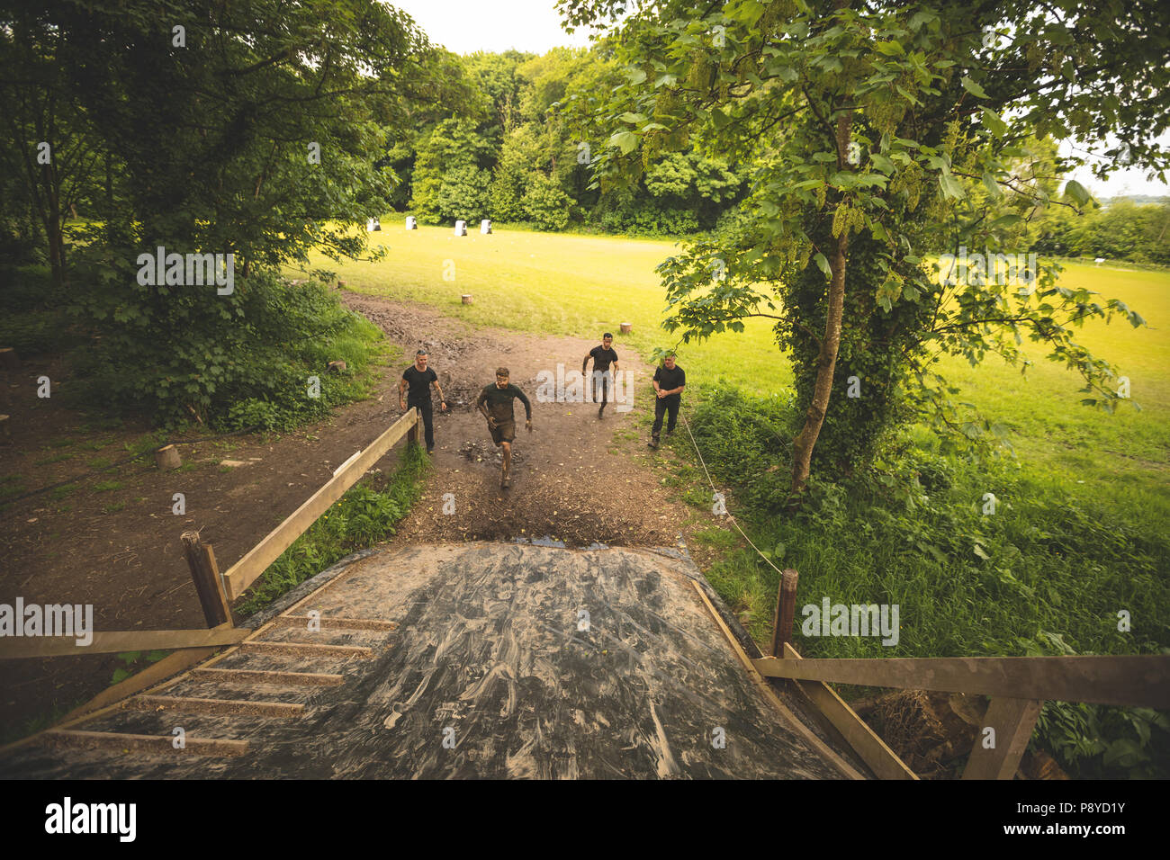 Group of men training over obstacle course Stock Photo - Alamy
