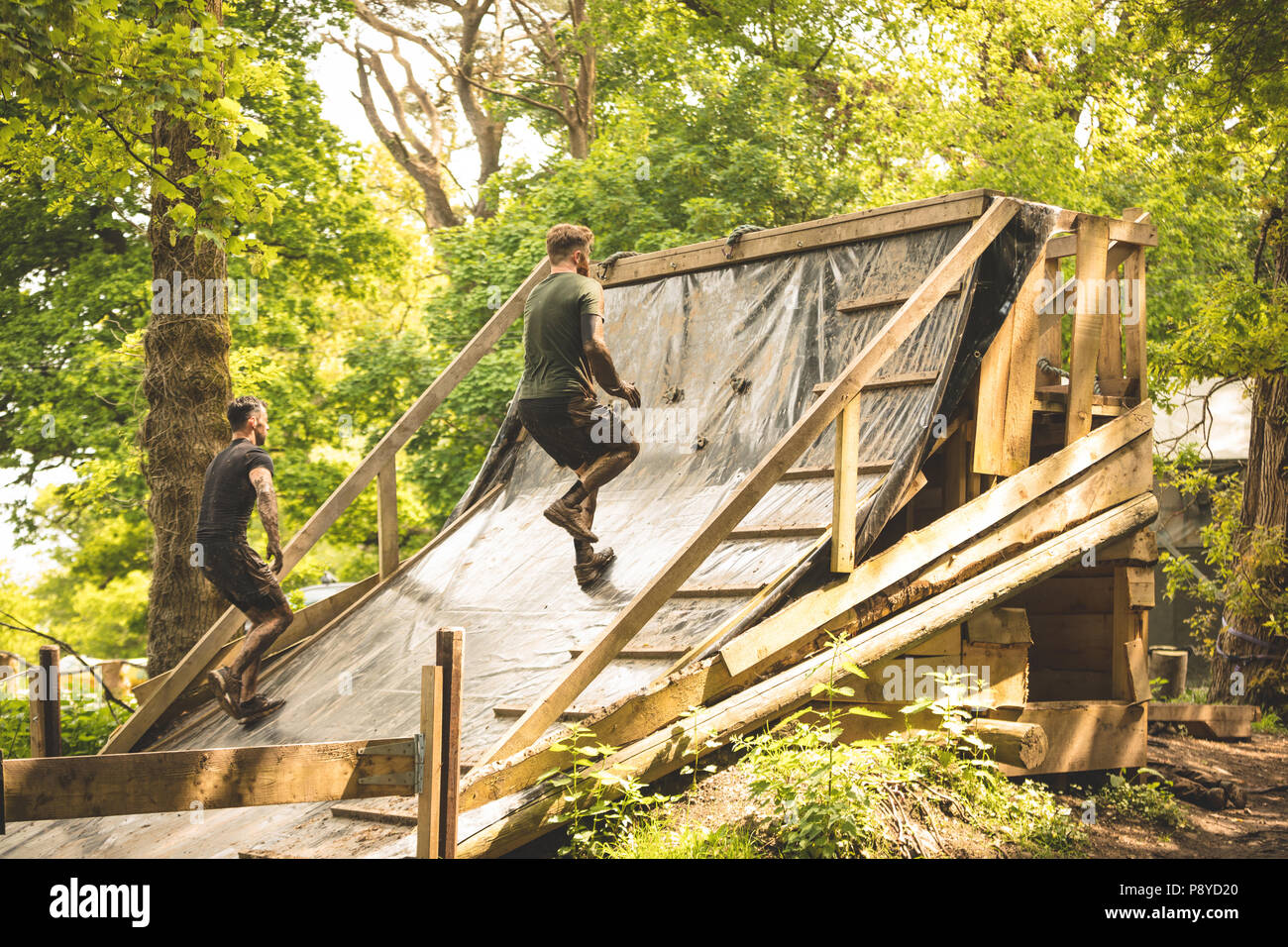 Fit men training over obstacle course Stock Photo - Alamy