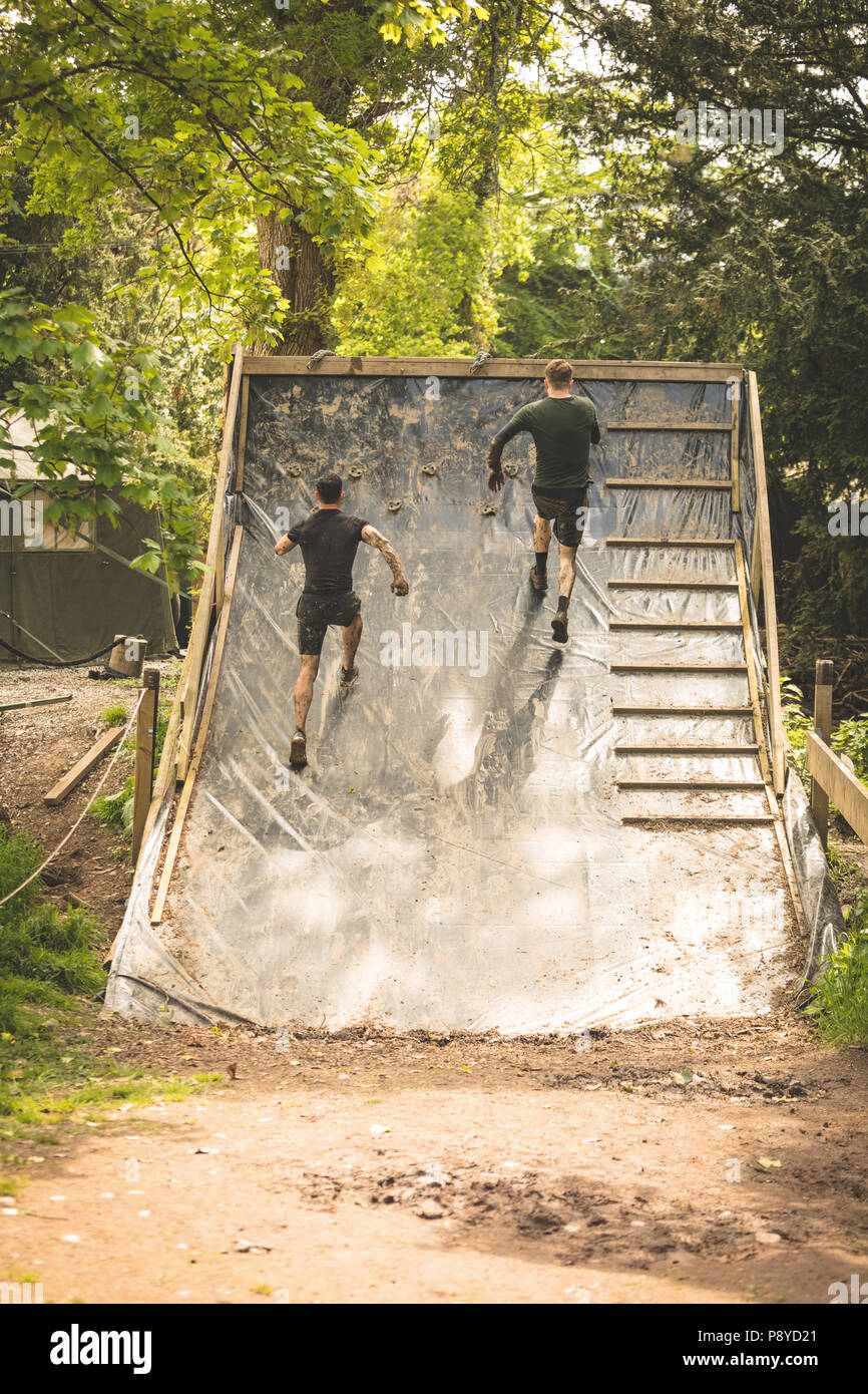 Fit men training over obstacle course Stock Photo - Alamy