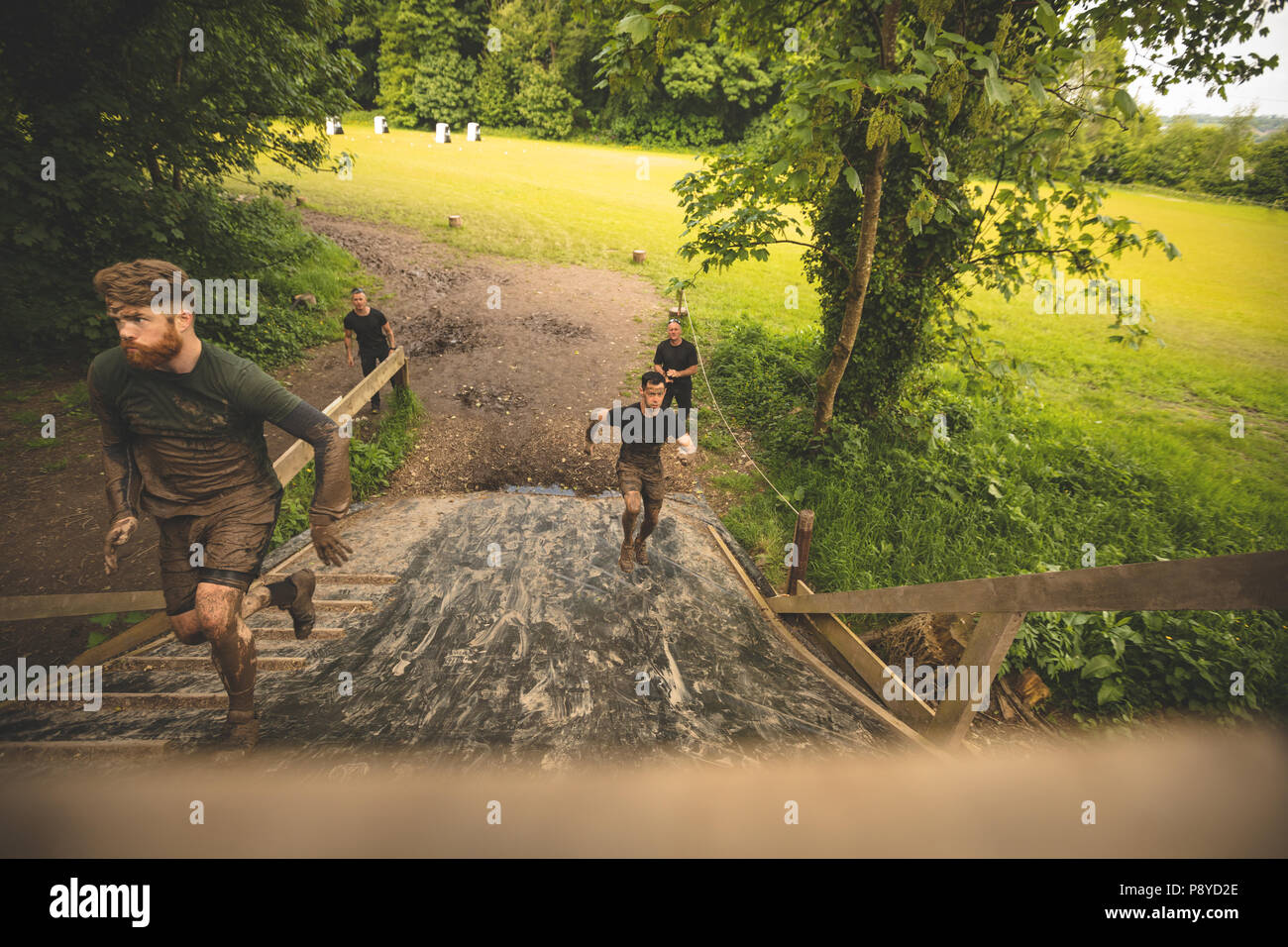 Fit men training over obstacle course Stock Photo - Alamy