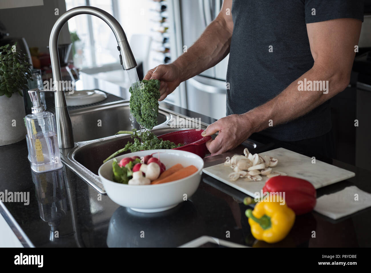 Man washing vegetables in kitchen Stock Photo - Alamy