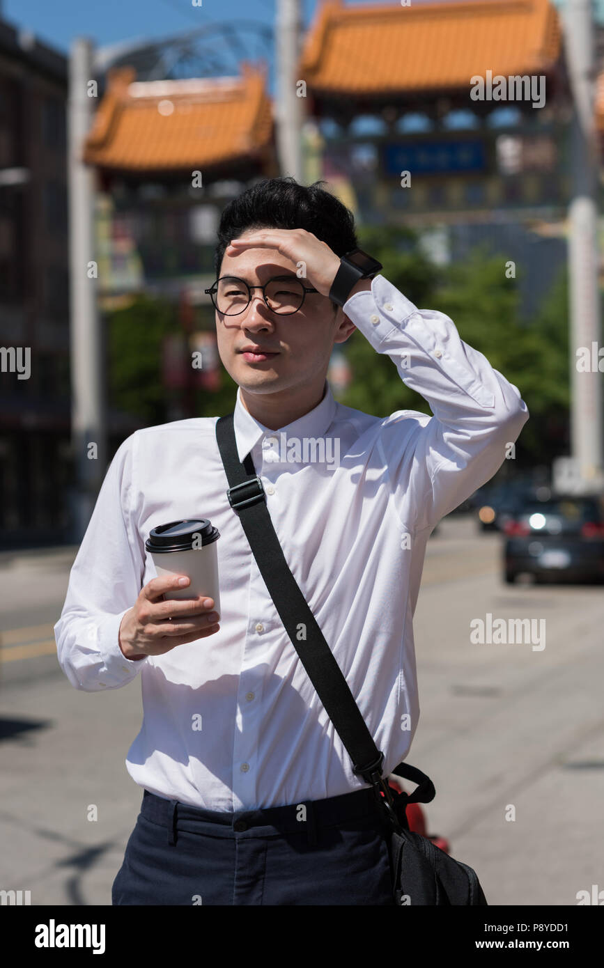 Man shielding his eyes while walking on the street Stock Photo - Alamy