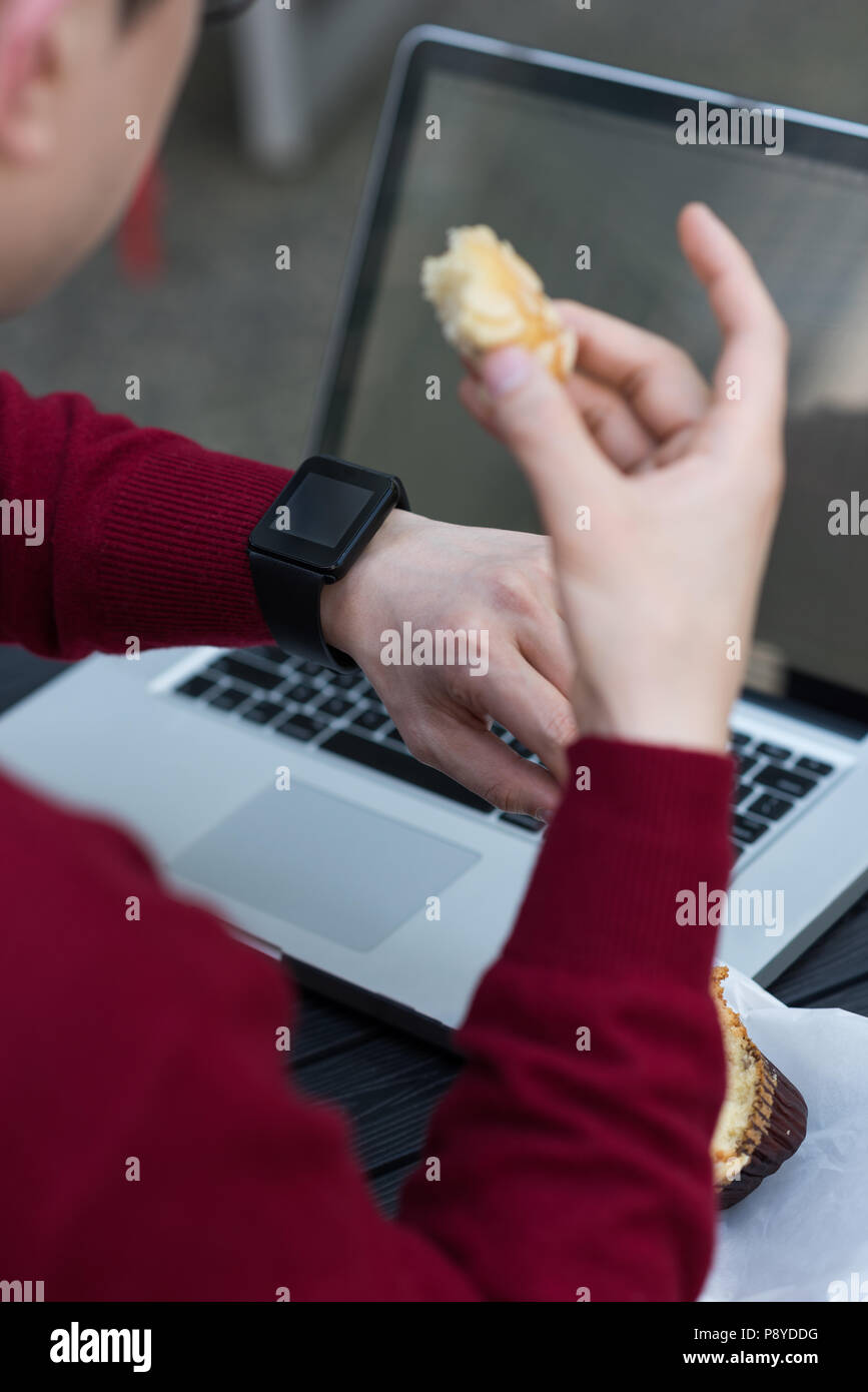 Man checking time on smartwatch at outdoor cafe Stock Photo - Alamy