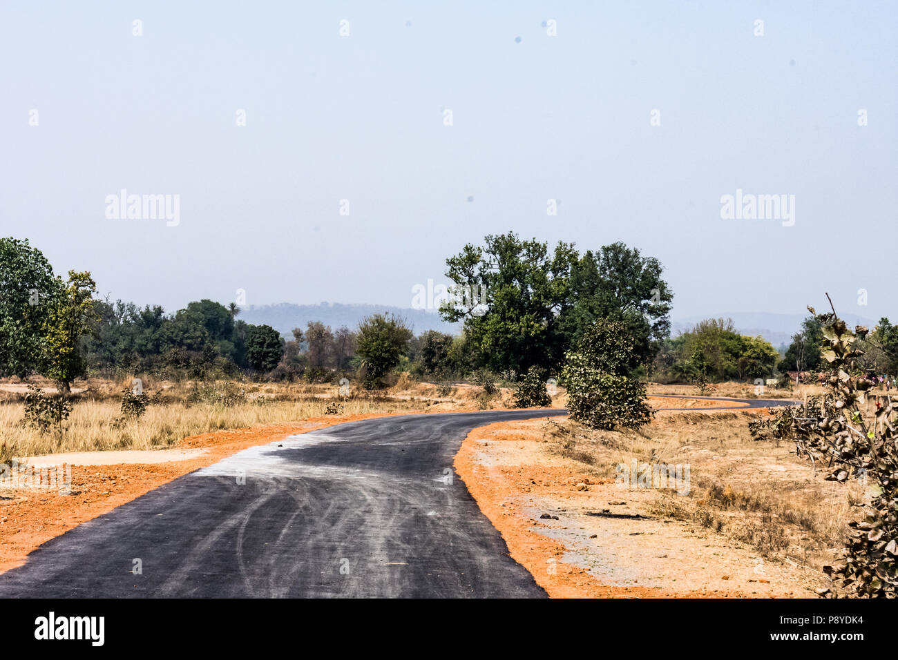 Rural Indian uphill pitch road highway meets the sky horizon through ...