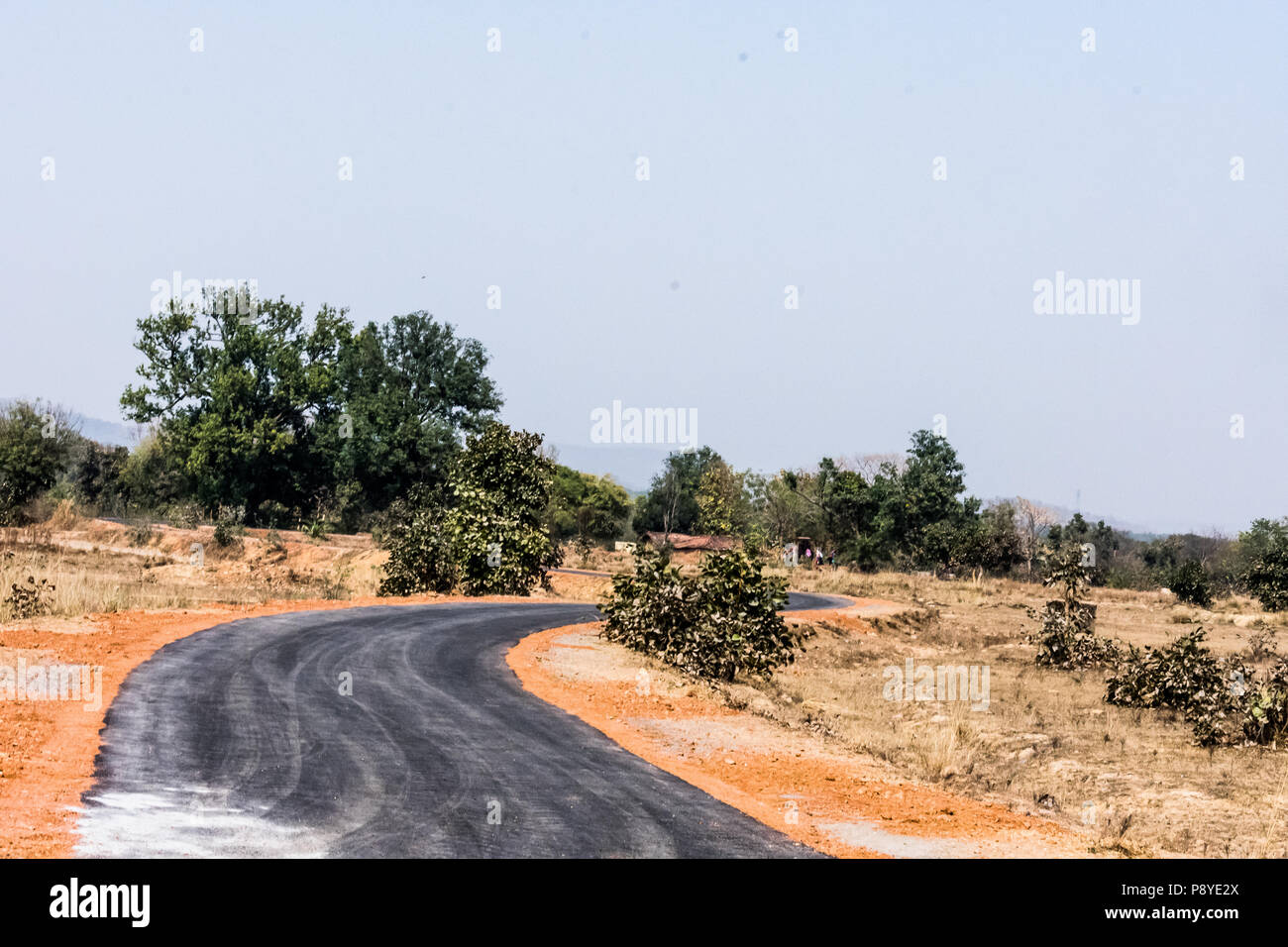 Rural Indian uphill pitch road highway meets the sky horizon through ...