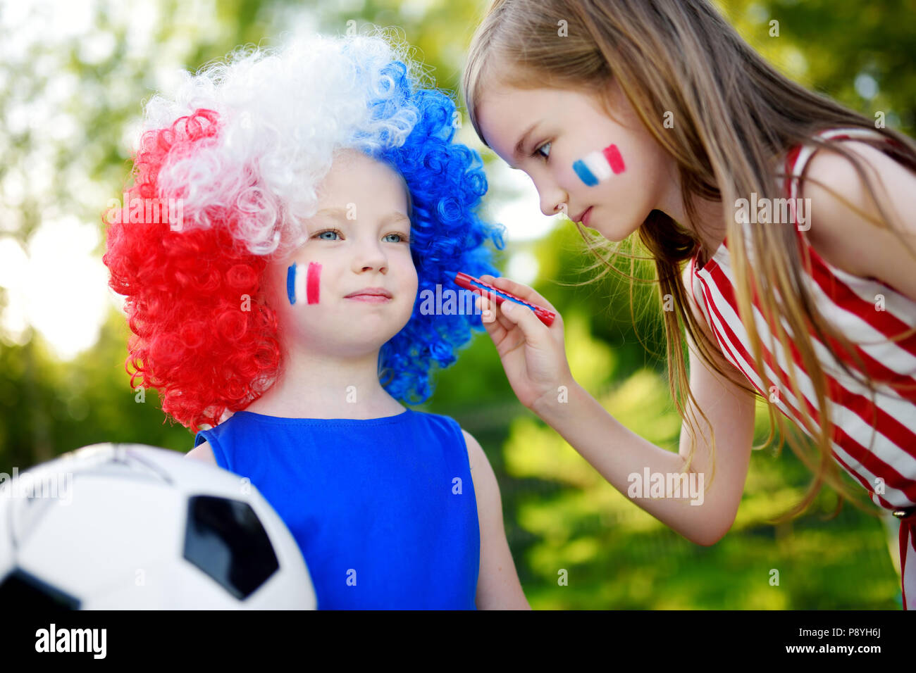 Two funny little sisters supporting and cheering their national ...