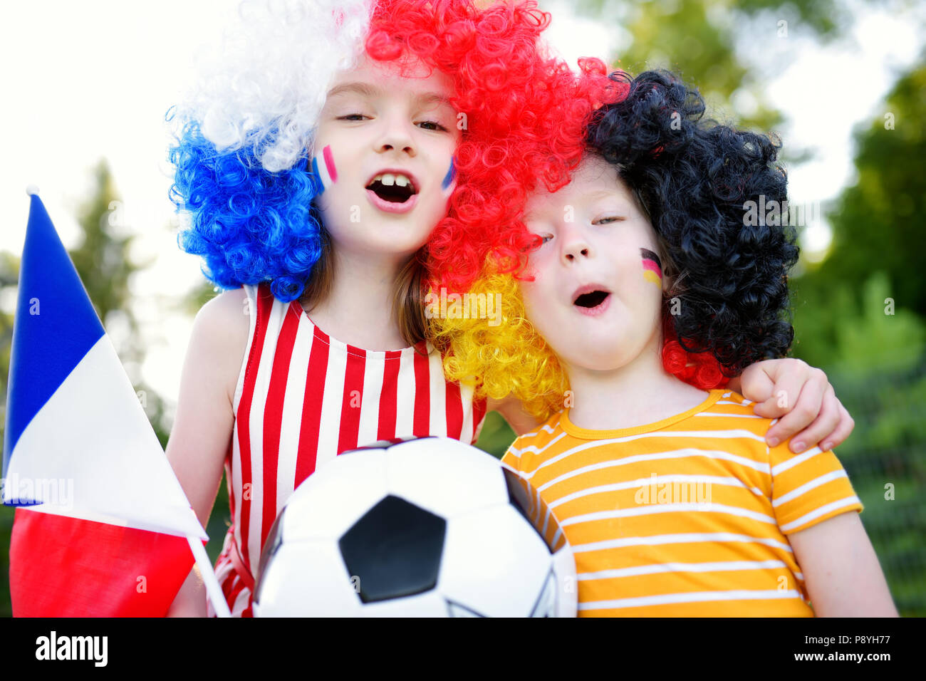 Two funny little sisters supporting and cheering their national ...