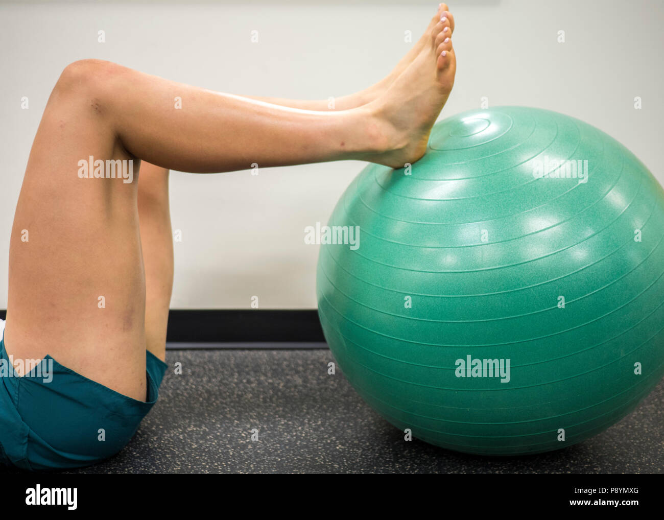Young women with her feet up on a green exercise ball Stock Photo - Alamy