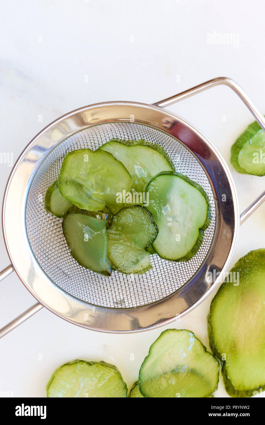 Sliced pickled gherkins in a sieve Stock Photo - Alamy