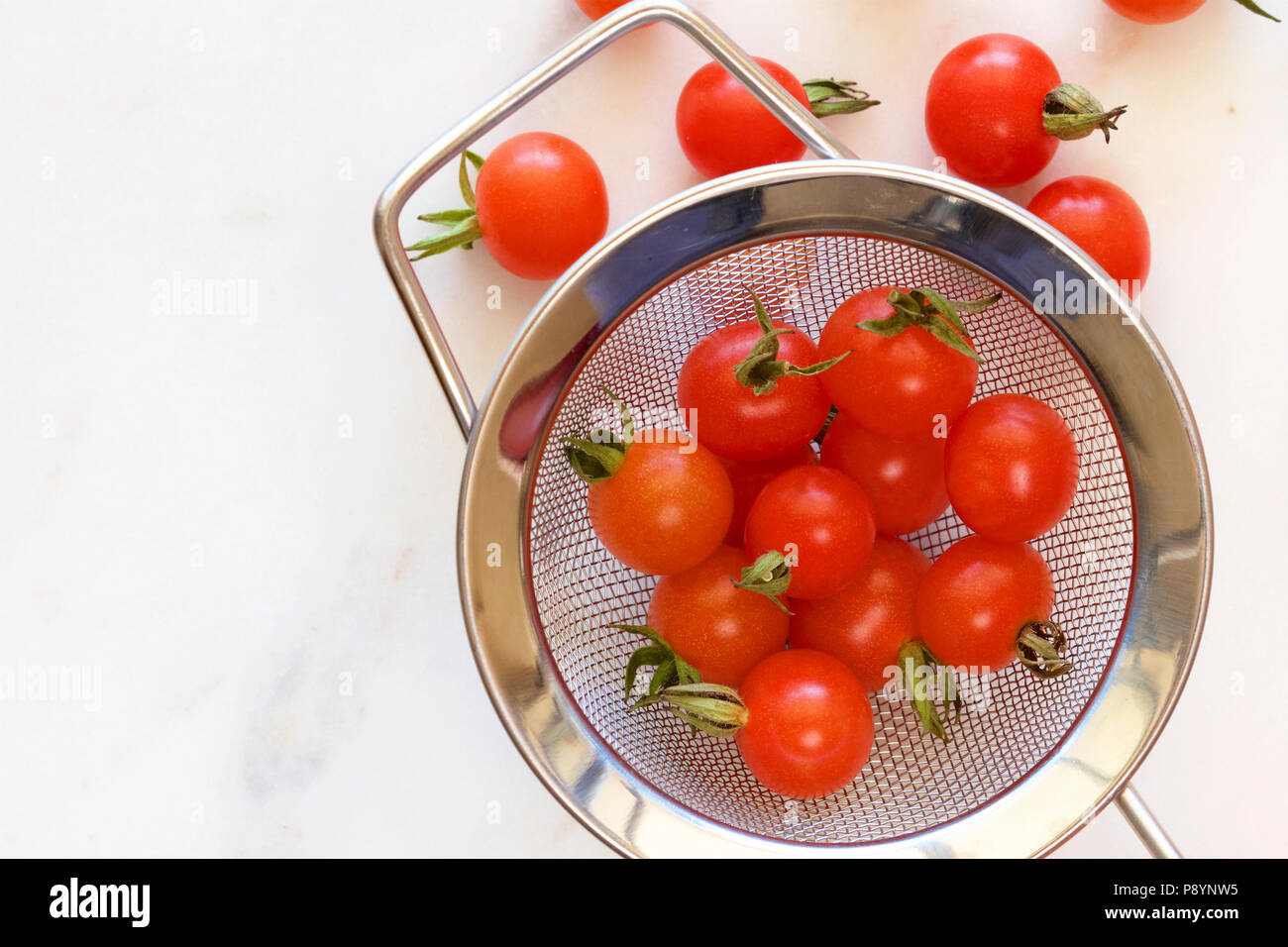 Tiny cherry tomatoes in a kitchen sieve Stock Photo - Alamy