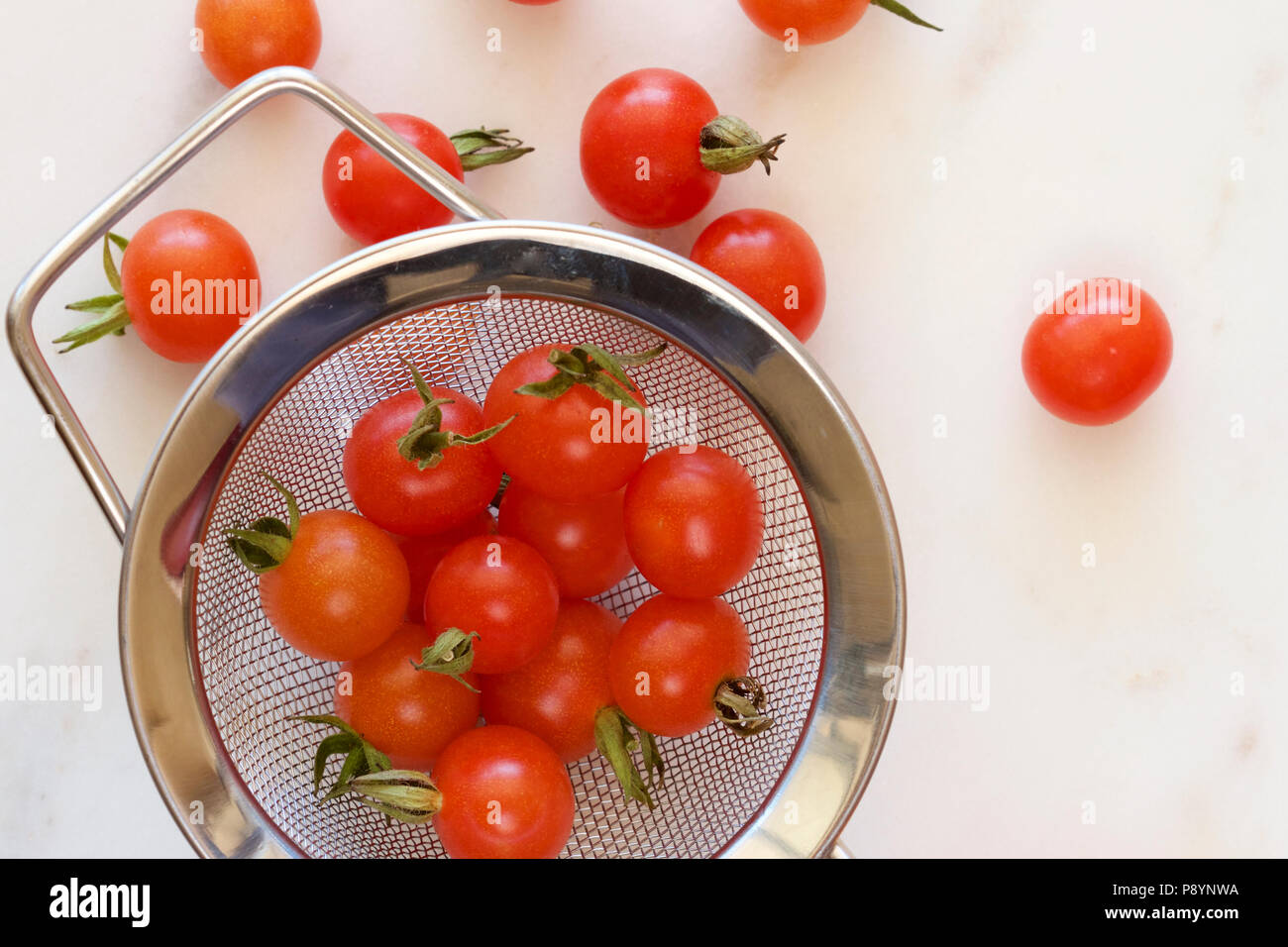 Tiny cherry tomatoes in a kitchen sieve Stock Photo - Alamy