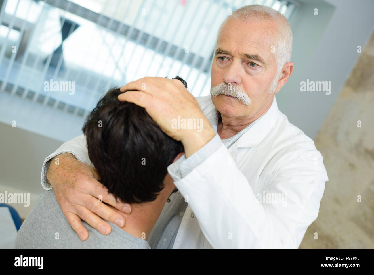 senior doctor doing head manipulation on patient Stock Photo - Alamy