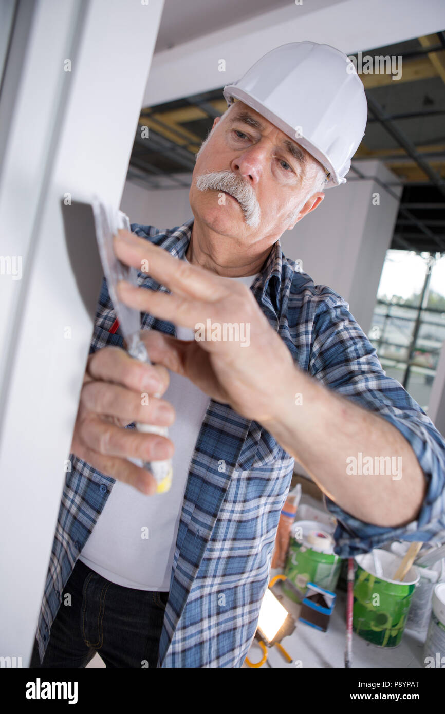 builder using device on wall Stock Photo - Alamy