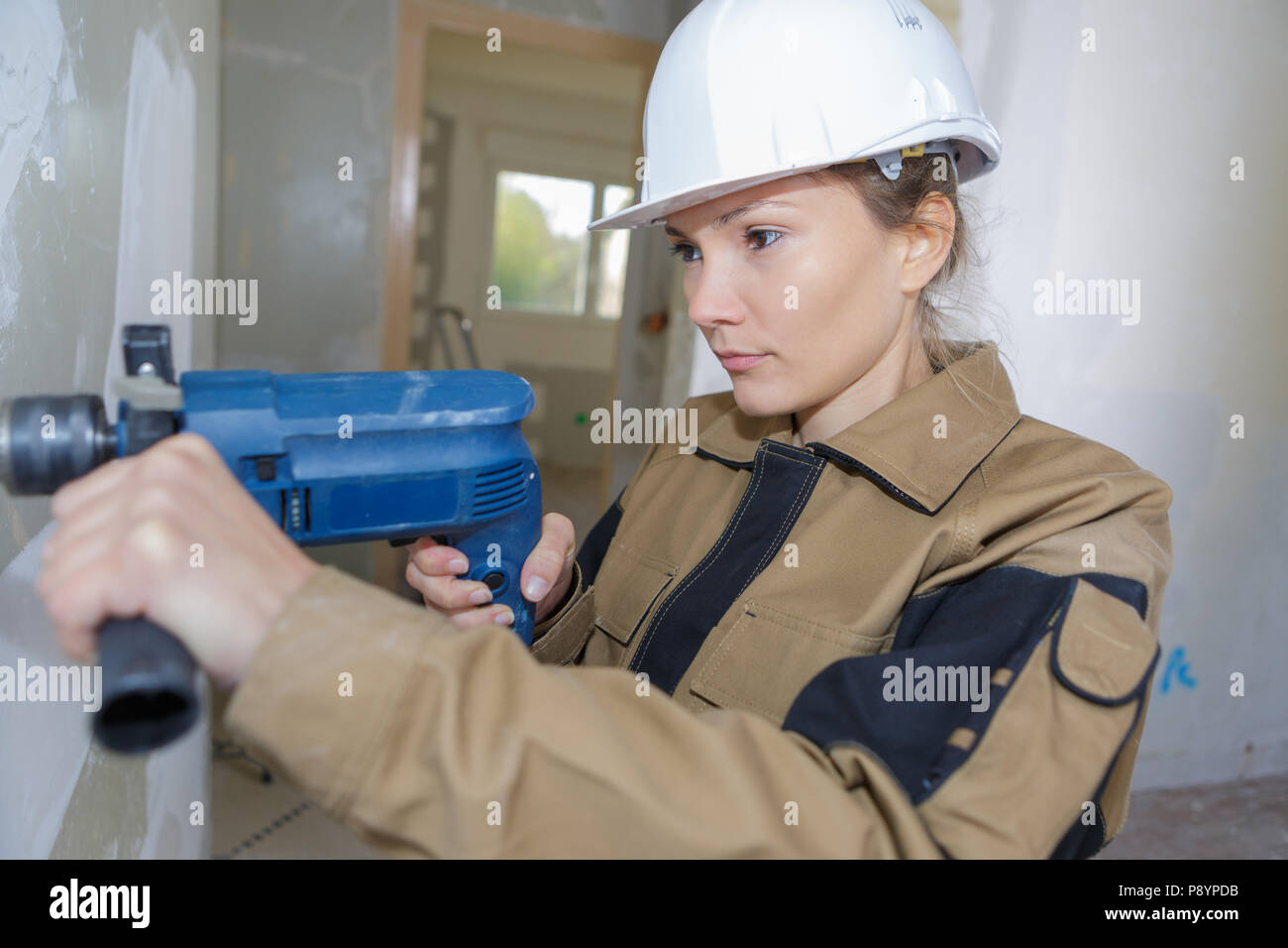 female construction worker drilling concrete wal Stock Photo - Alamy